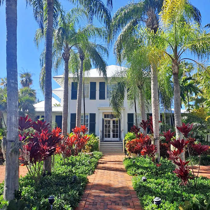 Colorful tropical plants frame the white house where a literary legend once typed his famous stories.