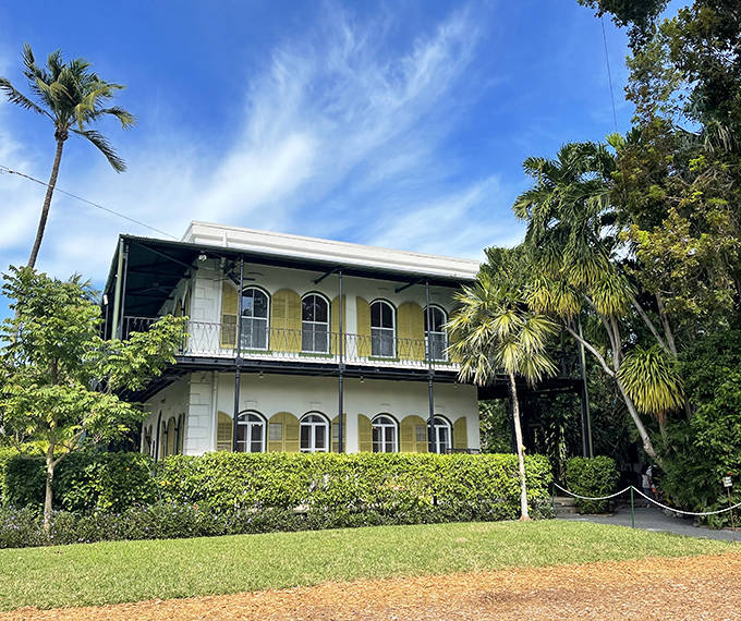 The mansion stands gracefully behind its garden like it's posing for a postcard from paradise.