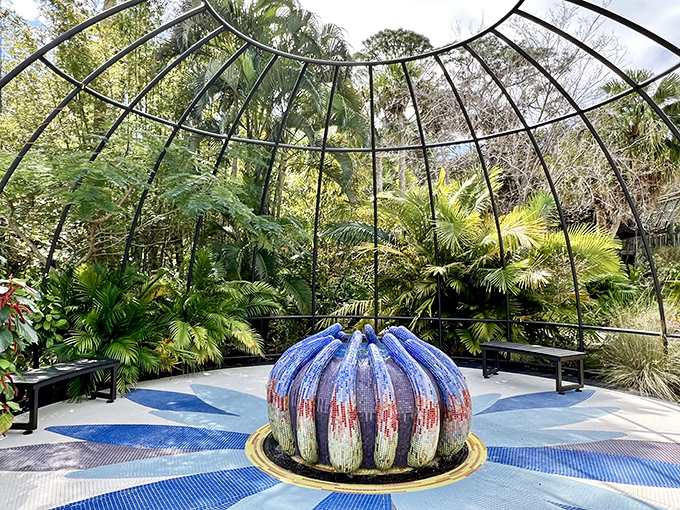 A vibrant, dome-like sculpture anchors this tropical sanctuary, where bold colors and lush foliage merge into a serene meeting of art and nature.
