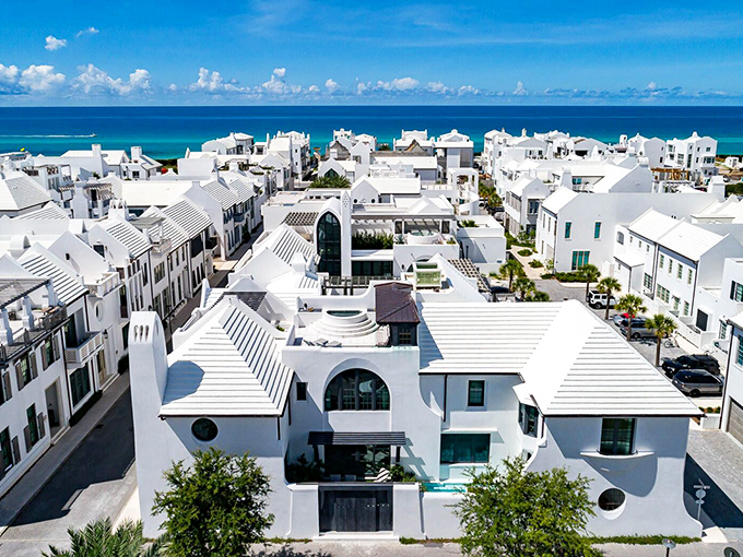 The community's distinctive white buildings create a dazzling contrast against the natural landscape, like a Greek island transported to Florida.