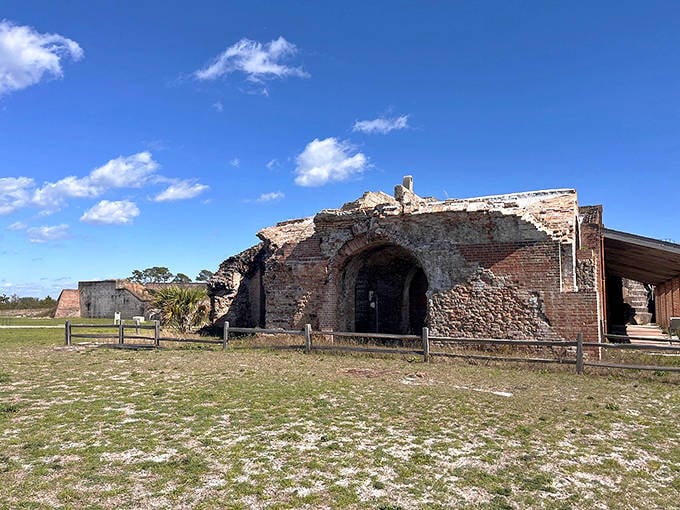 Fort Pickens' impressive stone entrance beckons history lovers to explore its passages, with visitors climbing the stairs to discover panoramic views.