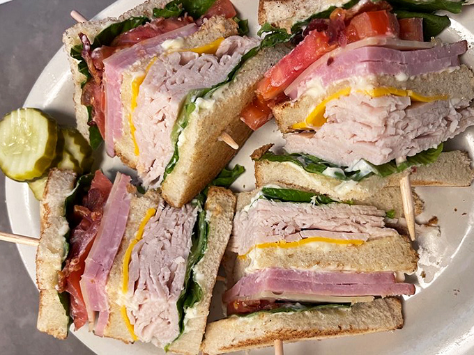 The club sandwich stands tall and proud, layers of meat, cheese, and veggies creating a handheld symphony that requires both hands and possibly a strategy session.