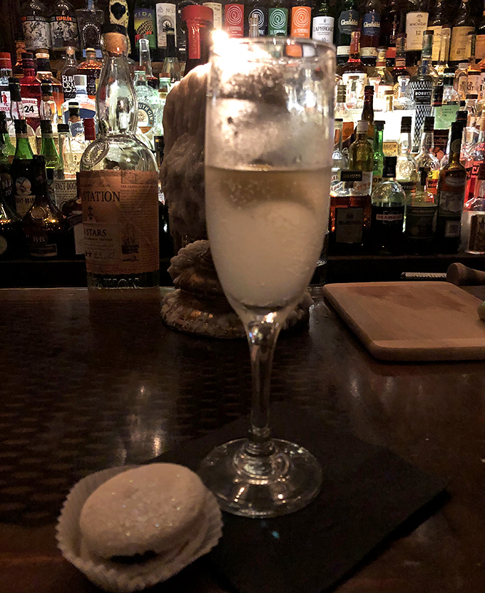 Daiquiri: Frothy perfection in a coupe glass, this daiquiri sits regally beside what appears to be a macaron &ndash; luxury in liquid and solid form.