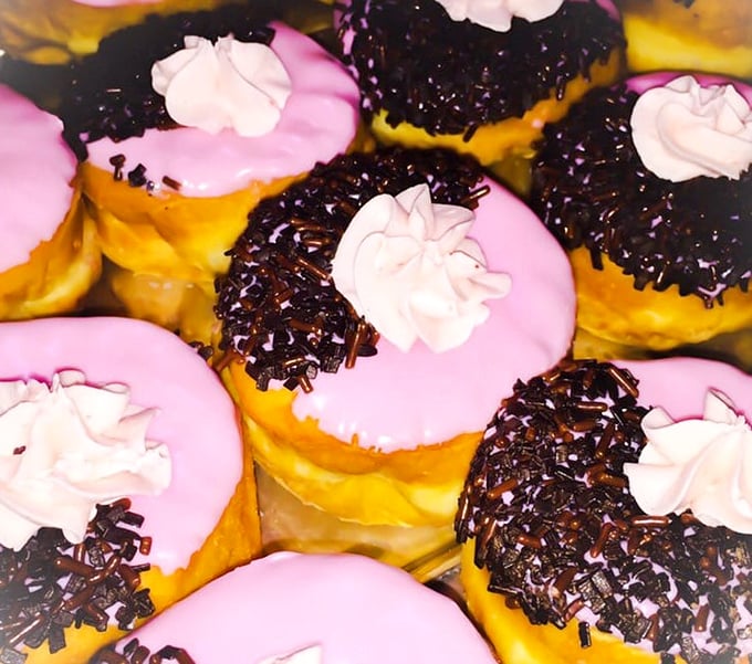 Pink-frosted doughnuts with chocolate sprinkles offer a whimsical contrast to The Castle's darker aesthetics, satisfying midnight cravings with unexpected sweetness.