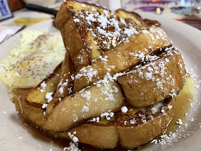 Thick-cut bread transformed into a cinnamon-kissed masterpiece, dusted with powdered sugar like a delicate Florida snowfall.