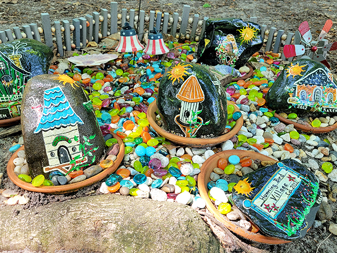 Miniature fairy dwellings nestle among colorful stones, creating a vibrant neighborhood that would make any sprite feel right at home.
