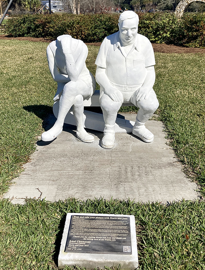 "Marie and Jean" sit in eternal companionship, their white forms creating striking contrast against the greenery&mdash;a frozen moment of human connection.