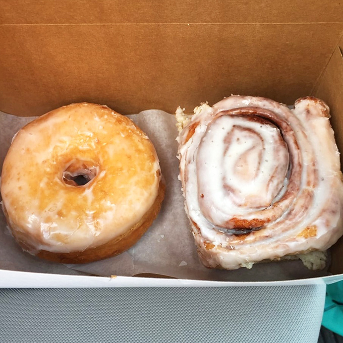 The dynamic duo: a classic glazed donut with a perfect sheen alongside a cinnamon roll with swirls hypnotic enough to make you forget your name.