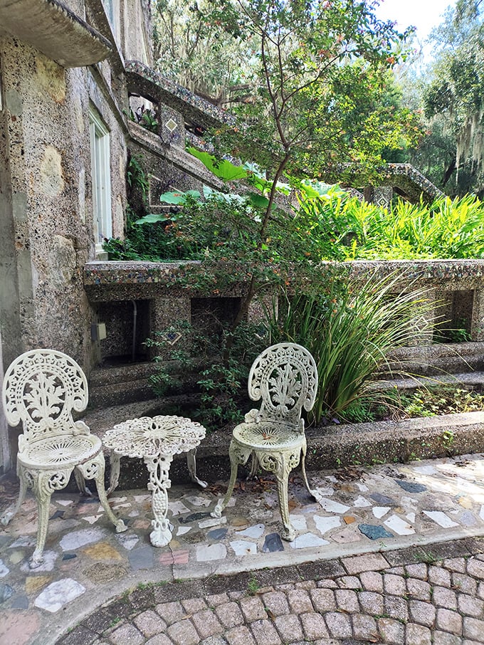 Nature's reclamation project in full swing, where vintage furniture provides seating for an audience of climbing vines and tropical plants.