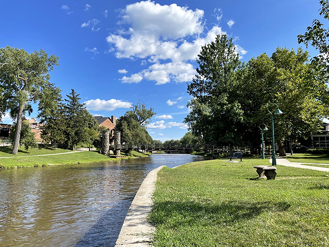 The Shiawassee River flows peacefully past manicured grounds, providing the same serene views that inspired Curwood's wilderness adventures.