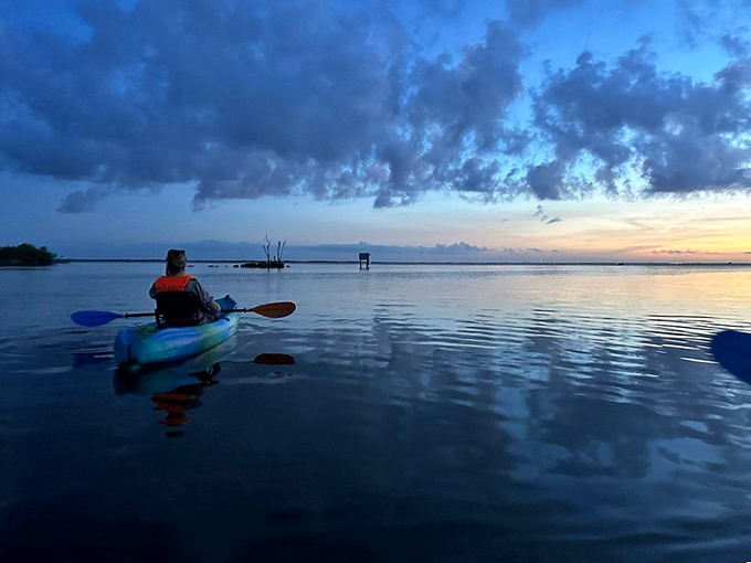 Sunset gives way to the main event as kayakers position themselves for nature's light show on perfectly calm waters.