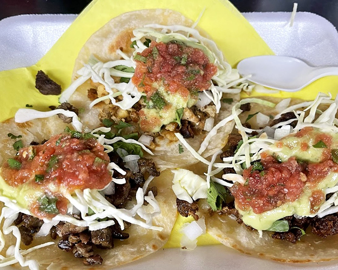 Three perfect tacos nestled on their yellow paper throne &ndash; each one a masterclass in the art of simplicity, where quality ingredients need no disguise.