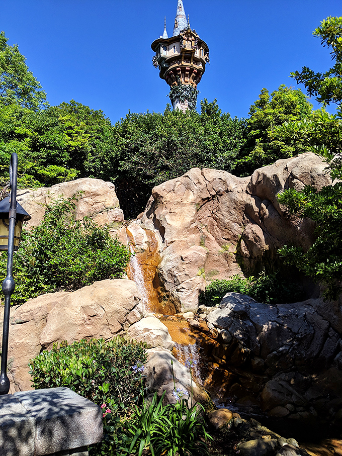 Rapunzel's tower peeks above the rockwork, a reminder that fairy tales are neighbors in this magical kingdom.