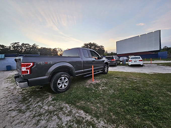 Pickup trucks claim prime viewing spots, their beds transformed into cozy nests of blankets &ndash; the original luxury box seats of drive-in culture.
