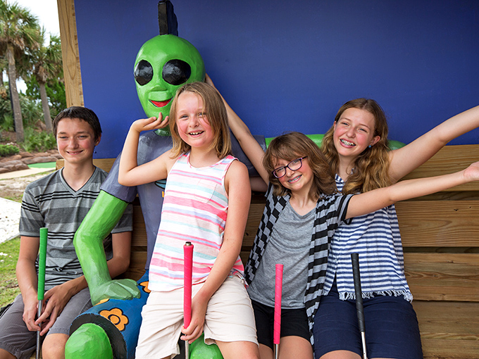 Visitors: Making friends with the locals! These young earthlings seem delighted with their green companion, who's clearly mastered the art of the perfect photo pose.