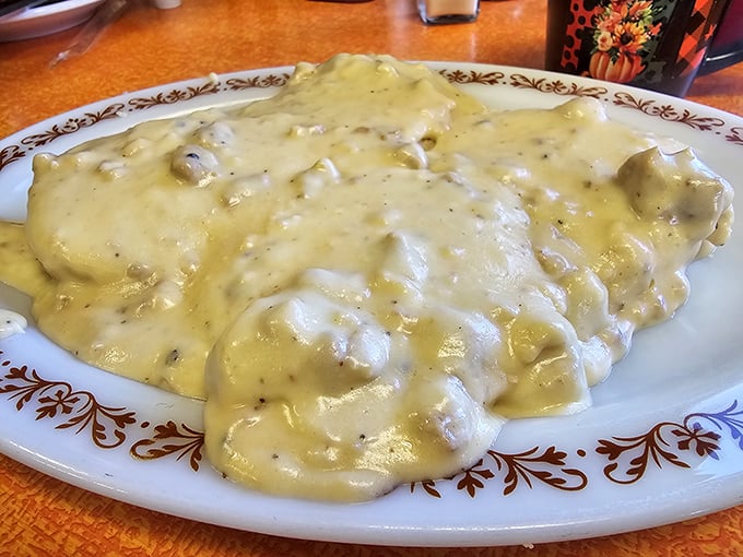 The gravy cascades over every inch like a savory waterfall, creating pools of flavor that you'll chase around the plate.