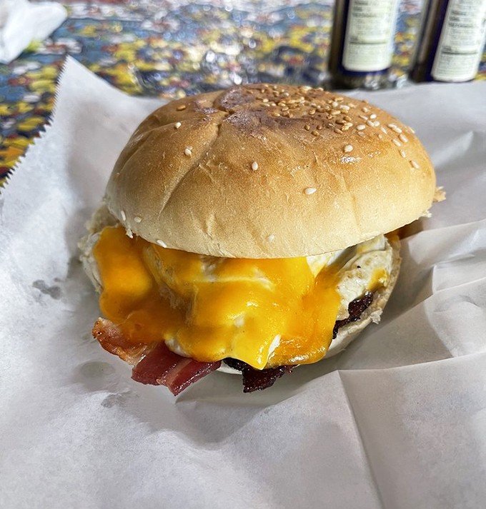 Cheese cascades over the patty like a molten waterfall, while bacon adds that smoky crunch that elevates this burger beyond fast-food territory.
