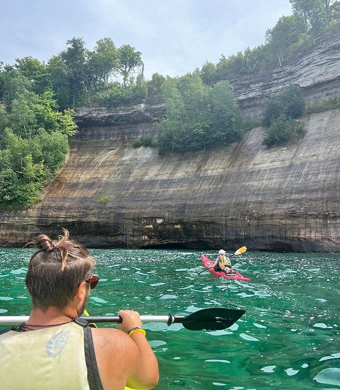 A paddler's perspective captures the immense scale of these mineral-stained cliffs, where each stroke brings new geological wonders into view.