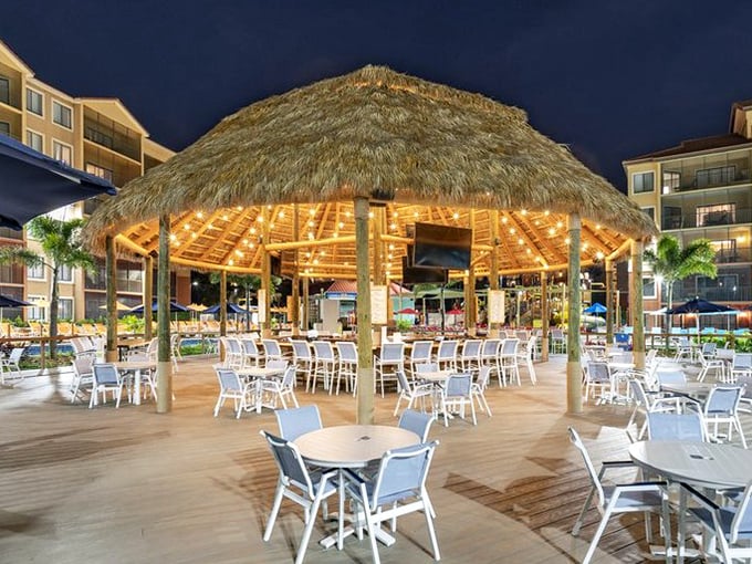 The thatched-roof bar area serves as an adult oasis where parents can rehydrate while maintaining the illusion of vacation sophistication.