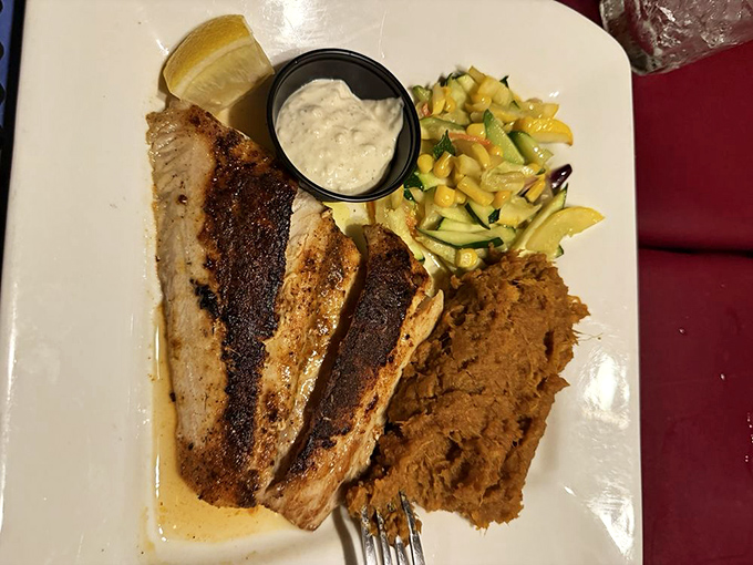 Blackened cobia with a side of sunshine &ndash; the fish wears its seasoning like a well-tailored suit, enhancing without overwhelming its natural flavor.