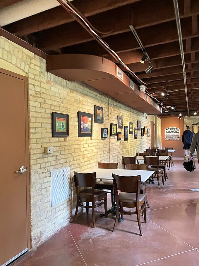 Brick walls frame intimate dining spaces where conversations and coffee flow freely – turning former institutional hallways into gathering spots that buzz with contemporary energy.