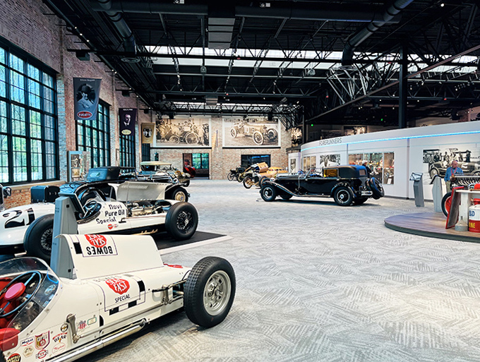 The main exhibit hall showcases automotive evolution from rudimentary racers to sophisticated speed machines, all under one spectacular roof with perfect lighting.