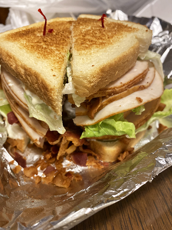 The club sandwich stands tall and proud, a skyscraper of turkey, bacon, and veggies that makes lunch feel like a celebration.
