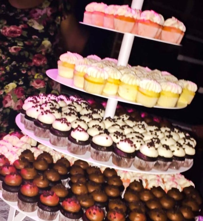 A towering display of cupcakes stands like a sugary monument, offering revelers a moment of childlike joy amidst the sophisticated Gothic surroundings.