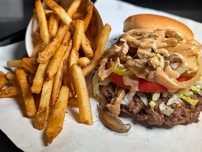 The perfect partnership: a burger that demands your full attention alongside fries that refuse to be mere sidekicks.