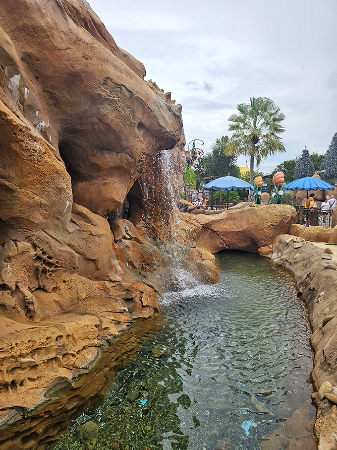 A gentle waterfall cascades down rocky formations, creating that perfect ambient soundtrack for your underwater fantasy.