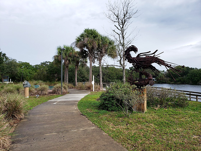 Nature frames creativity along this winding path &ndash; sculptures peek out between palm fronds, inviting visitors deeper into the park's artistic landscape.