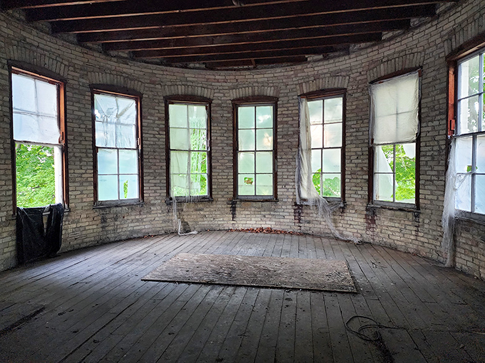 Sunlight streams through tall windows in this circular room, demonstrating the Kirkbride design philosophy that natural light could help heal troubled minds.