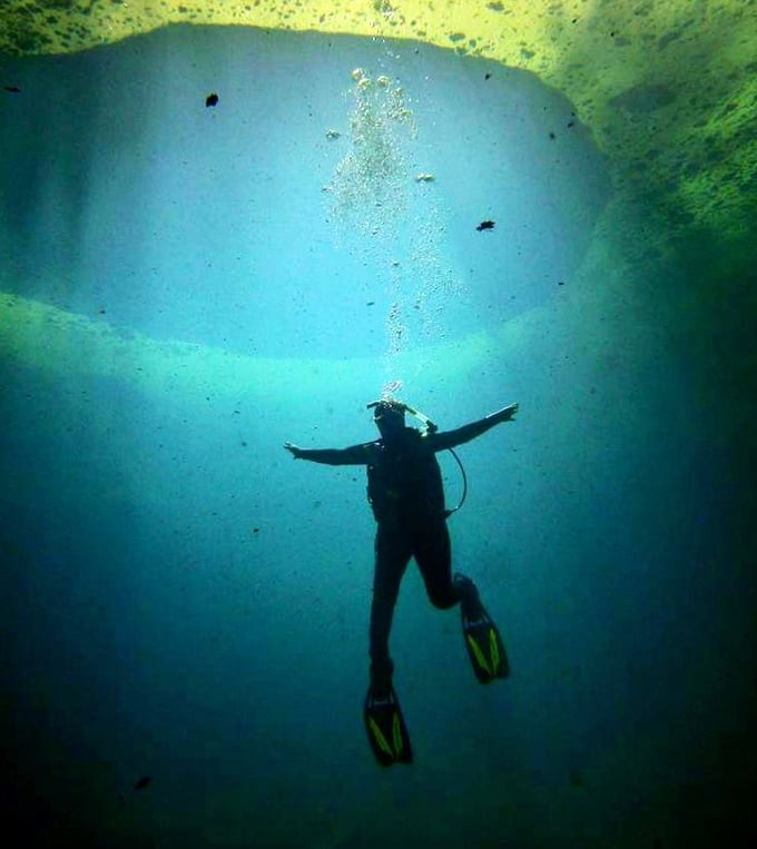 The mysterious blue hole punctuates the algae carpet&mdash;nature's portal to an extensive underwater cave network below.