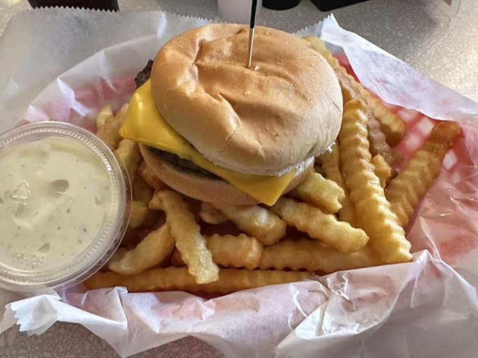The classic steakette burger doesn't need fancy toppings or artisanal buns&mdash;just cheese, meat, and the promise of napkins. Those fries look like they're auditioning for a food commercial.