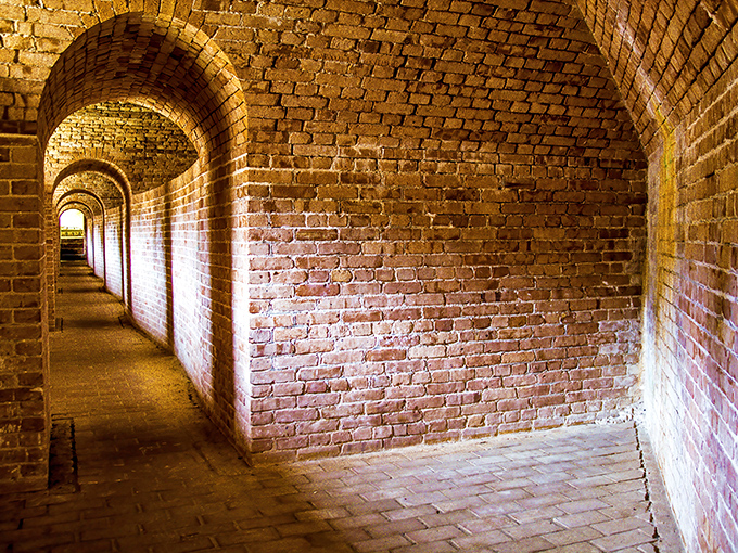 Brick archways create an optical illusion of infinity, drawing visitors deeper into the fort's defensive genius.