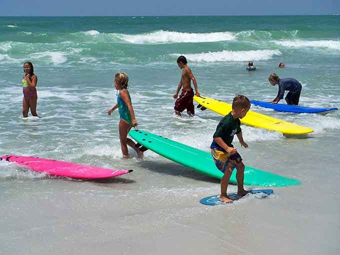 Future surf champions getting their start in the gentle Gulf waves, proving you're never too young to chase the perfect ride.
