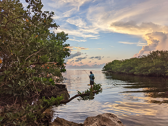 As sunset paints the sky in watercolor hues, a lone angler casts into the peaceful waters where mangroves meet Gulf &ndash; fishing doesn't get more scenic than this.