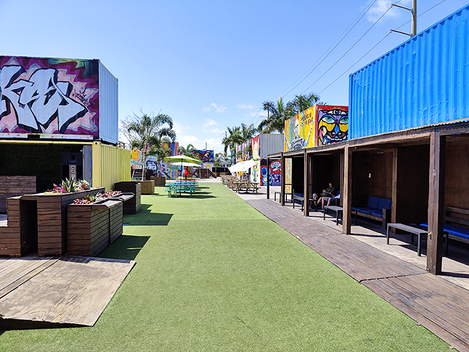 Stroll down this green pathway flanked by colorful containers &ndash; it's like walking through a garden where street art blooms instead of flowers.