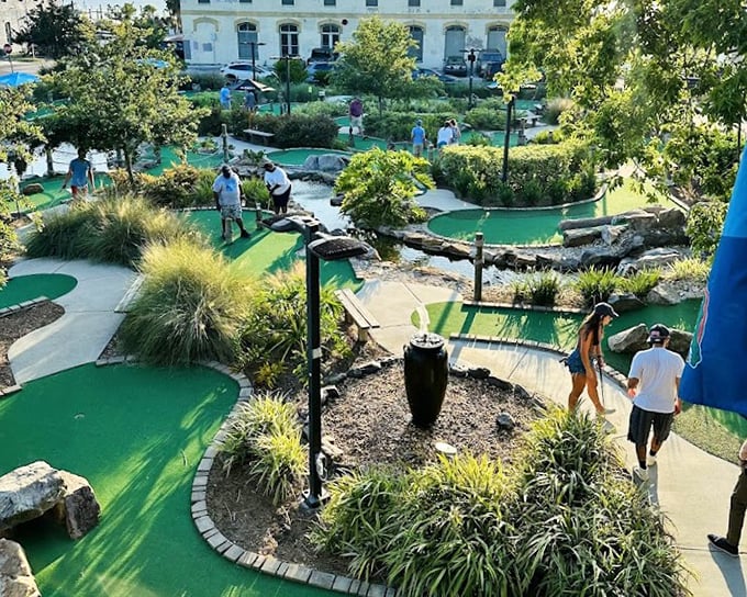 Sunlight dapples through trees onto the emerald putting surfaces where friends compete with drinks in one hand, putters in the other.