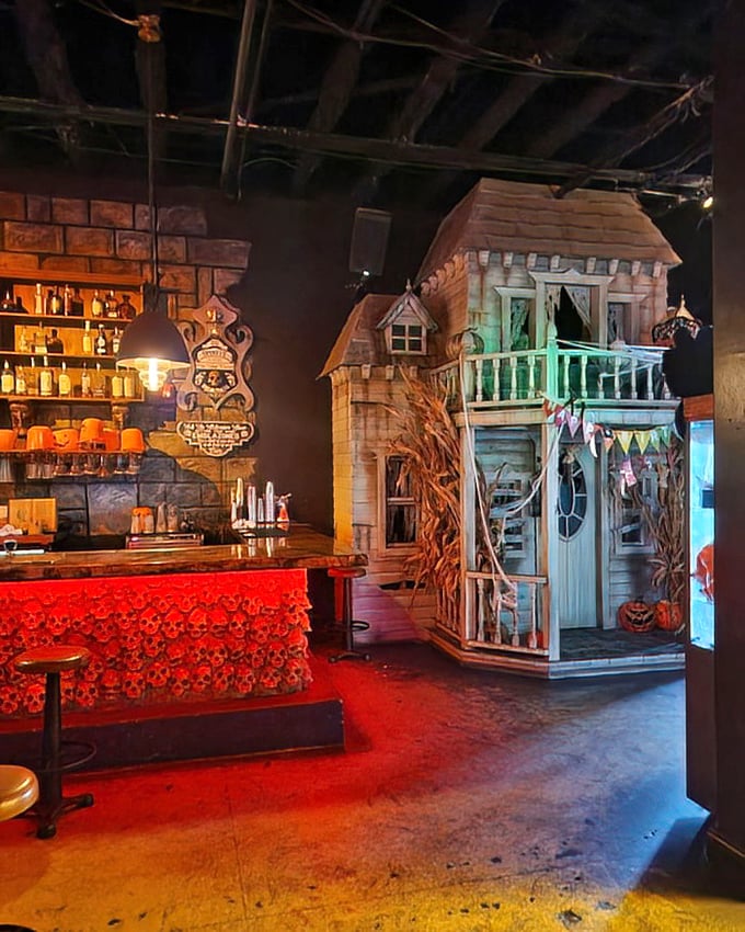 The miniature haunted house structure serves as a unique focal point, complete with tiny balcony and weathered siding.