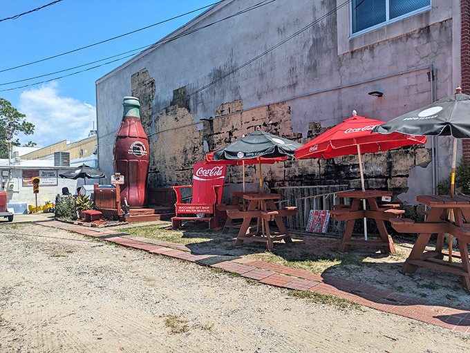Outdoor seating area where visitors can rest weary shopping feet while contemplating their next carbonated acquisition under Coca-Cola's signature red umbrellas.