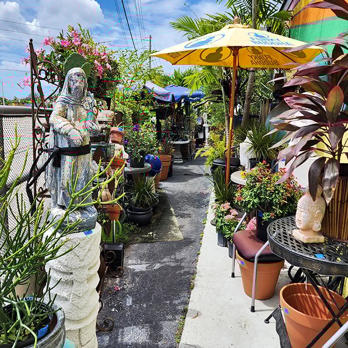 A garden path lined with plants and statues creates a whimsical outdoor shopping experience &ndash; like Alice's Wonderland with price tags.