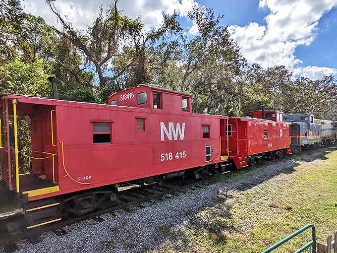 This vibrant red Norfolk and Western Railway caboose pops against Florida's blue sky, a crimson reminder of railroading's colorful past.