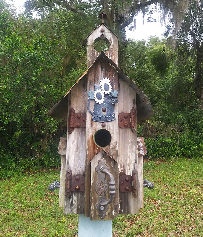 Not your average birdhouse! This whimsical wooden creation looks like it houses spirits with excellent taste in rustic architecture and decorative hardware.