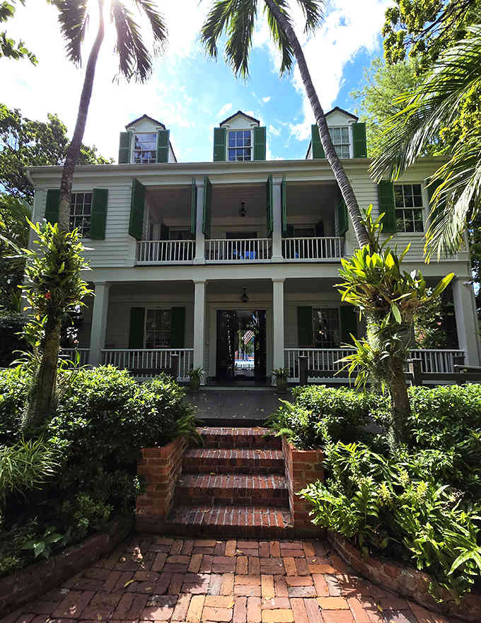 Two-story porches and an American flag create the perfect picture of historical elegance surrounded by tropical beauty.