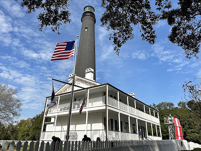 The dramatic black and white pattern of Pensacola Lighthouse creates a powerful silhouette, with a rocket trail nearby highlighting Florida's connection to both sea and space.
