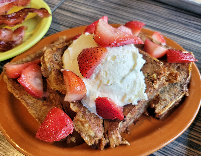 French toast that makes ordinary breakfast feel inadequate – a cinnamon-scented cloud topped with berries and cream that's worth setting an alarm for.