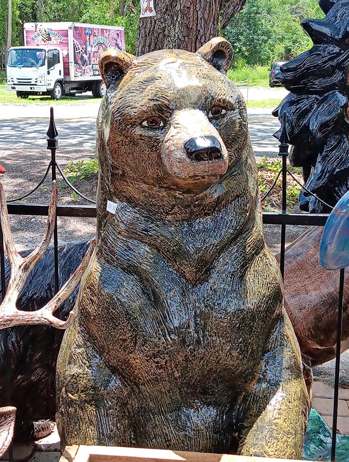A beautifully detailed bear statue watches over the yard art kingdom with a dignified, wilderness presence.