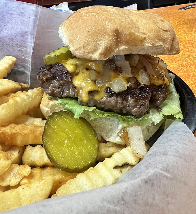 This isn't just a burger—it's a hand-held celebration of beef, cheese, and pickle, surrounded by golden fries that snap with each bite.