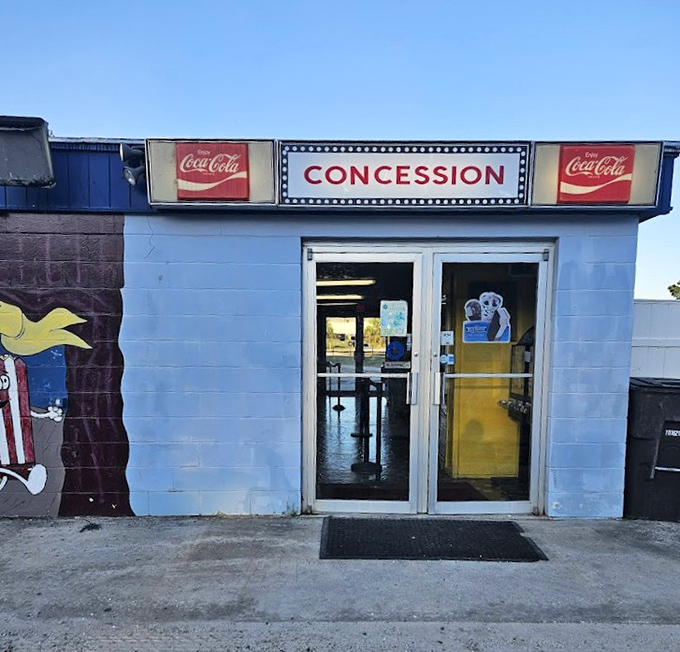 The concession building stands as a temple to movie snacks, its vintage Coca-Cola signage promising treats that taste better in the open air.